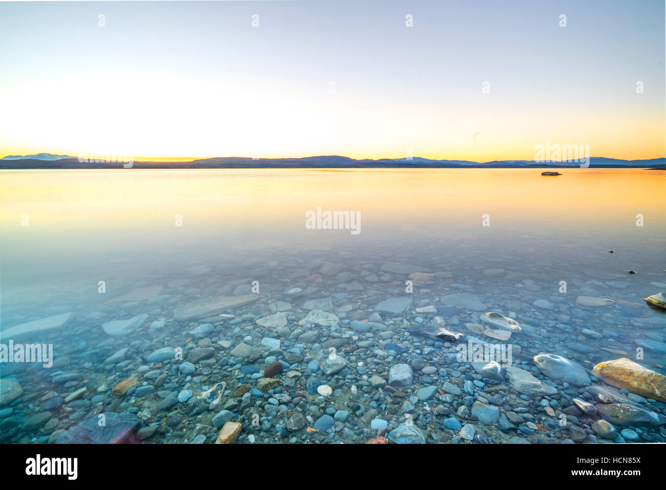 Stone lake with sunrise background Stock Photo - Alamy