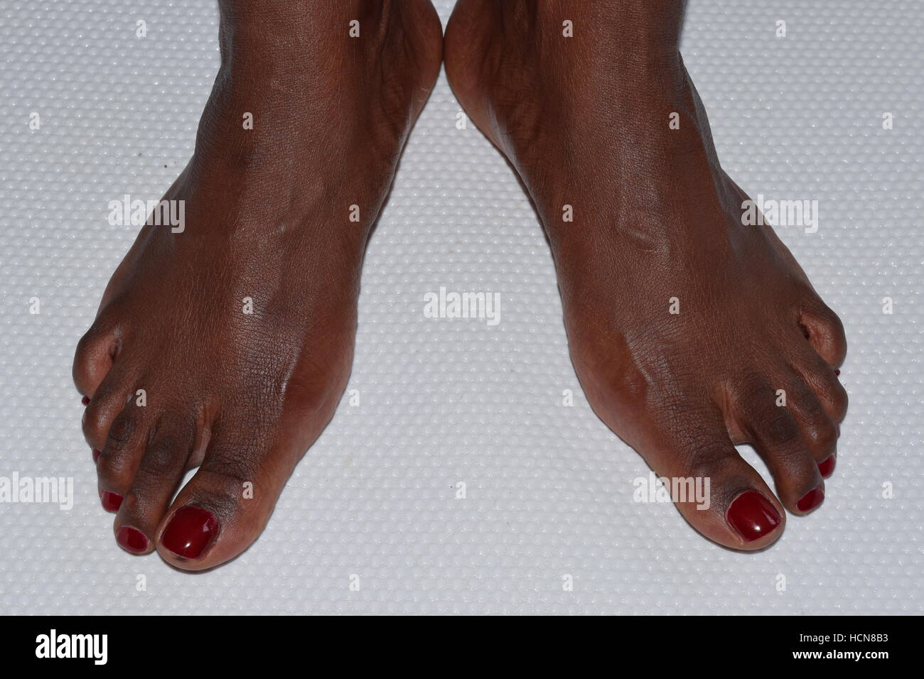 Two female feet facing outwards on a white surface Stock Photo - Alamy