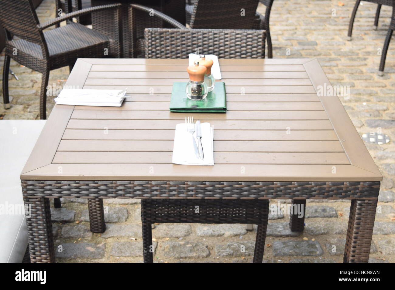 Set wooden tables for three at an outdoor restaurant seating area Stock ...