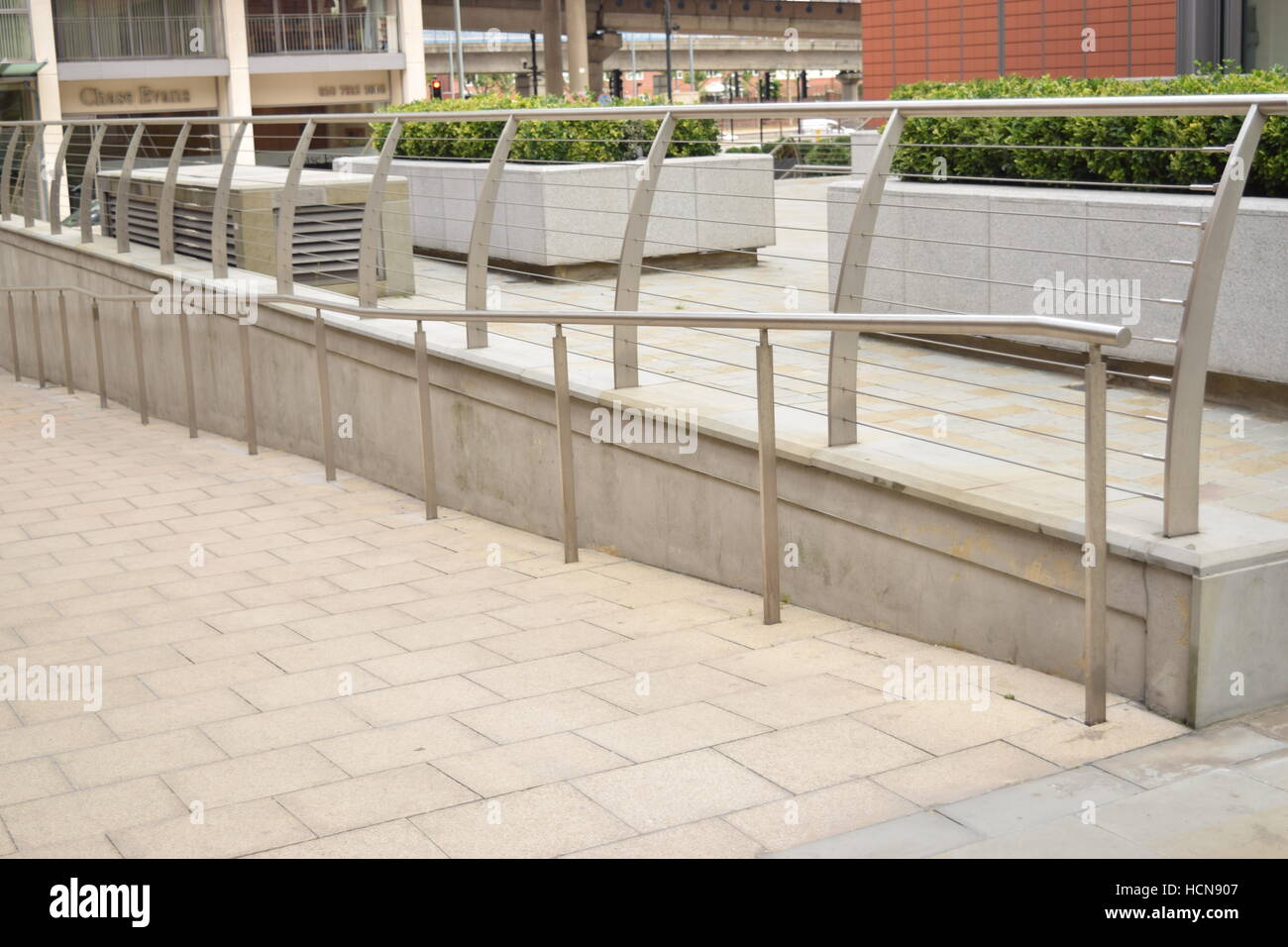 Long row of railings leading to the high street shops on Canary wharf ...