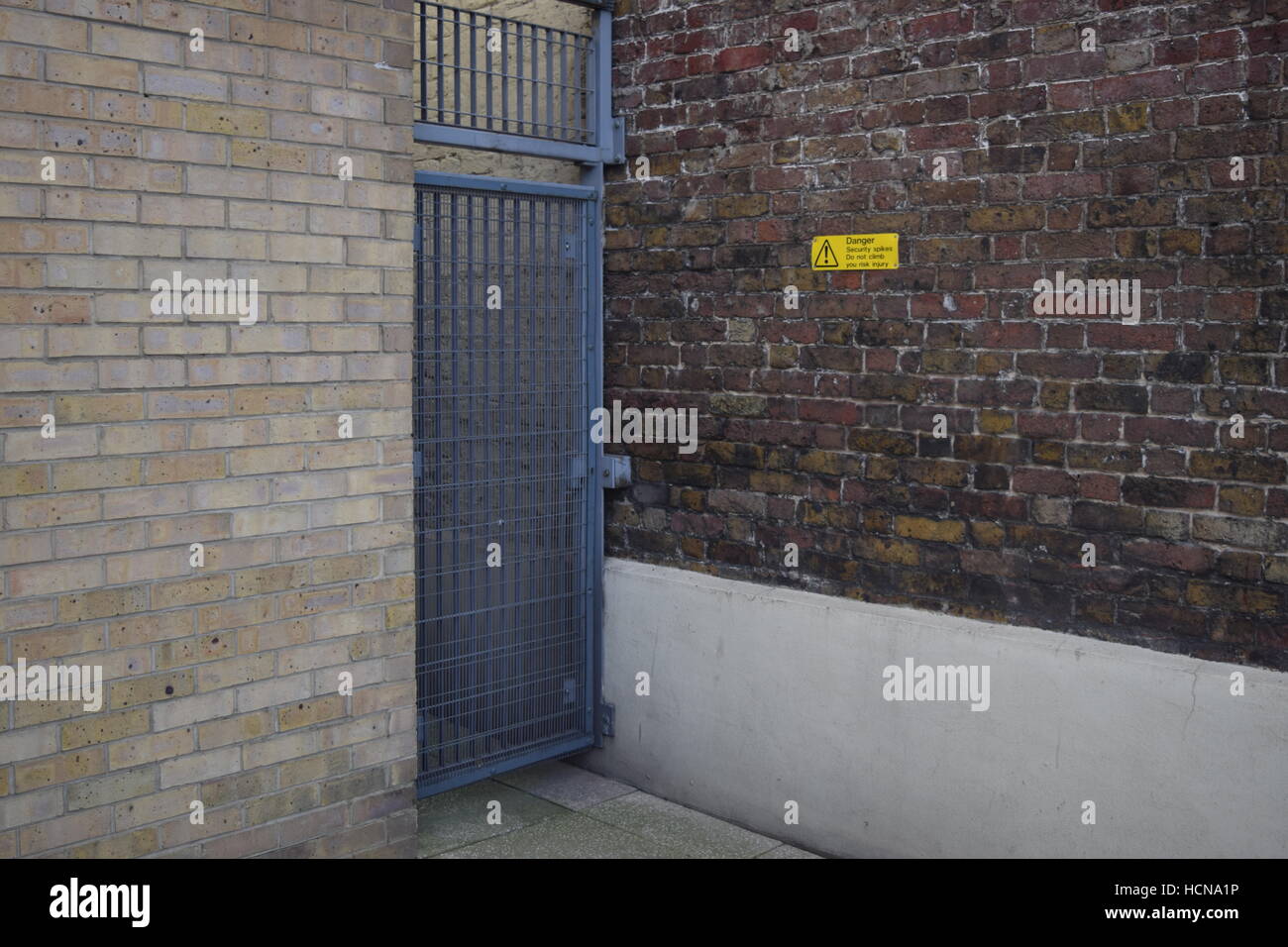 Small metallic side gate exit in between two brick walls Stock Photo ...