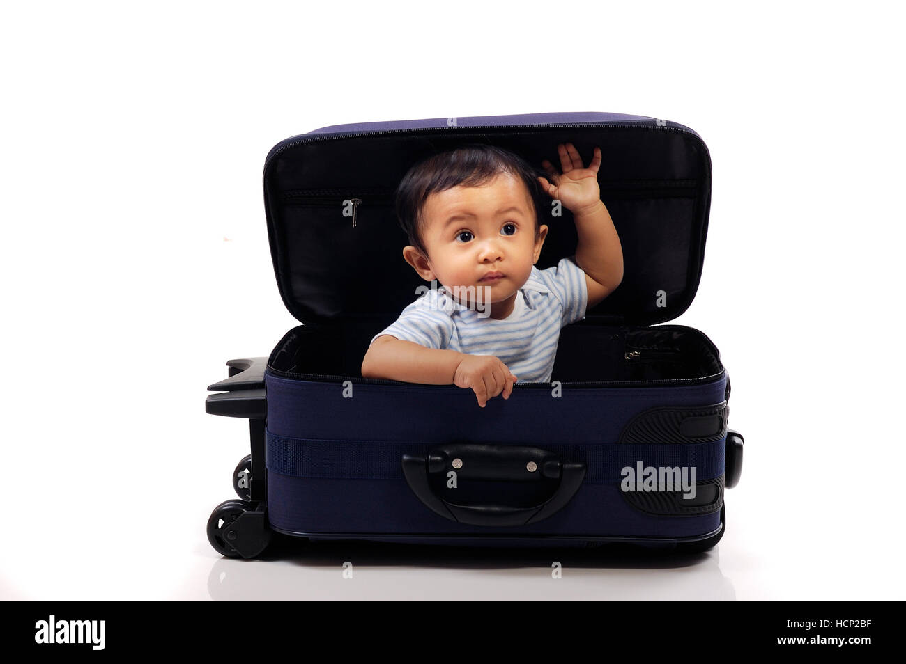 Baby girl in the blue suitcase on white background. Ready to travel ...