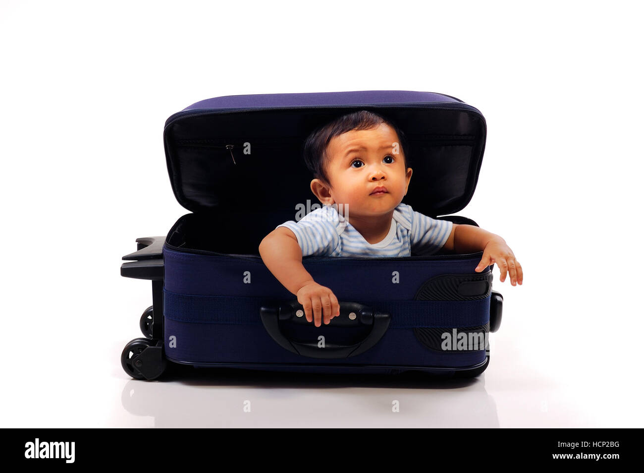 Baby girl in the blue suitcase on white background. Ready to travel ...