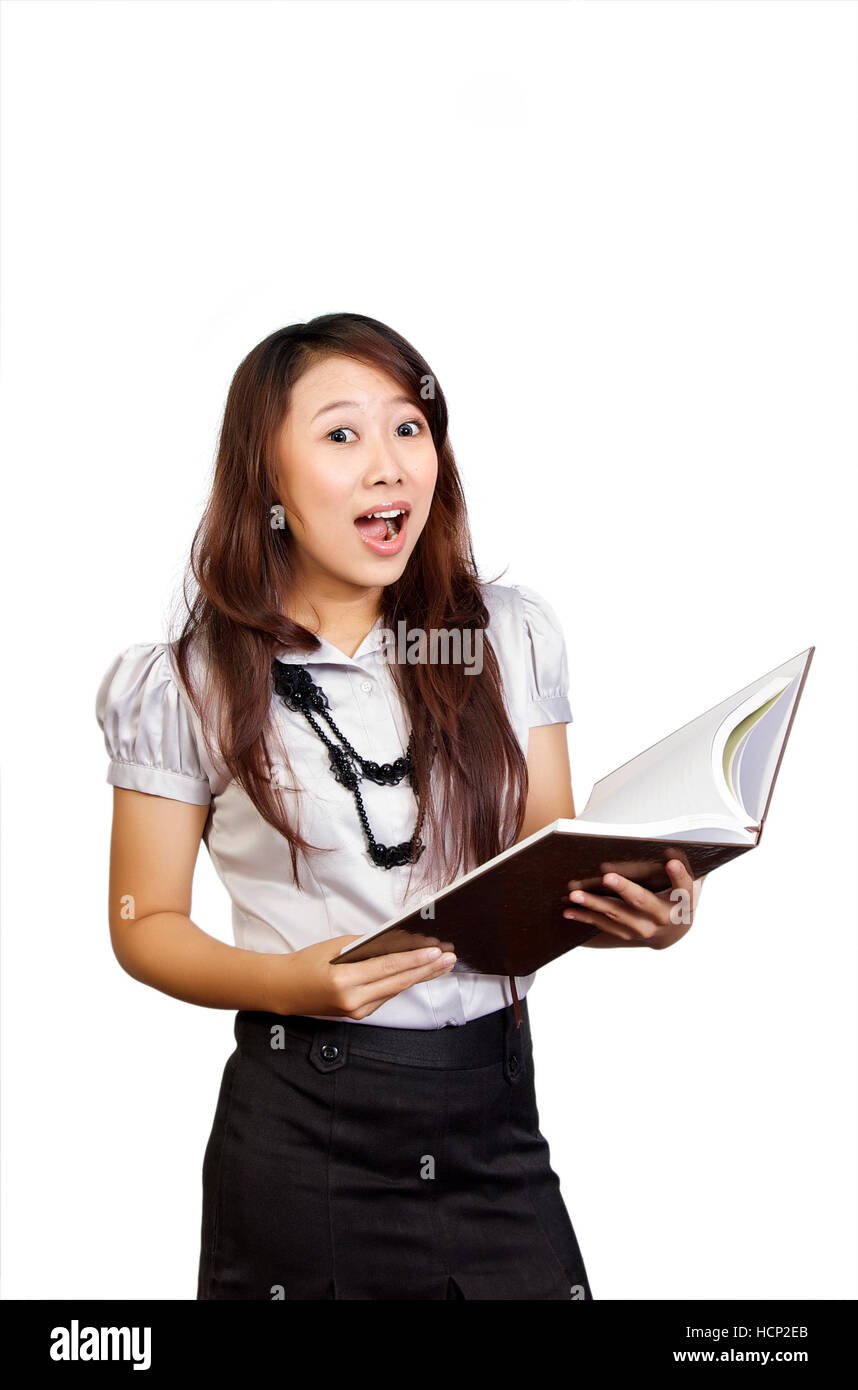 Beautiful college student reading book in her hand. She looks surprise ...