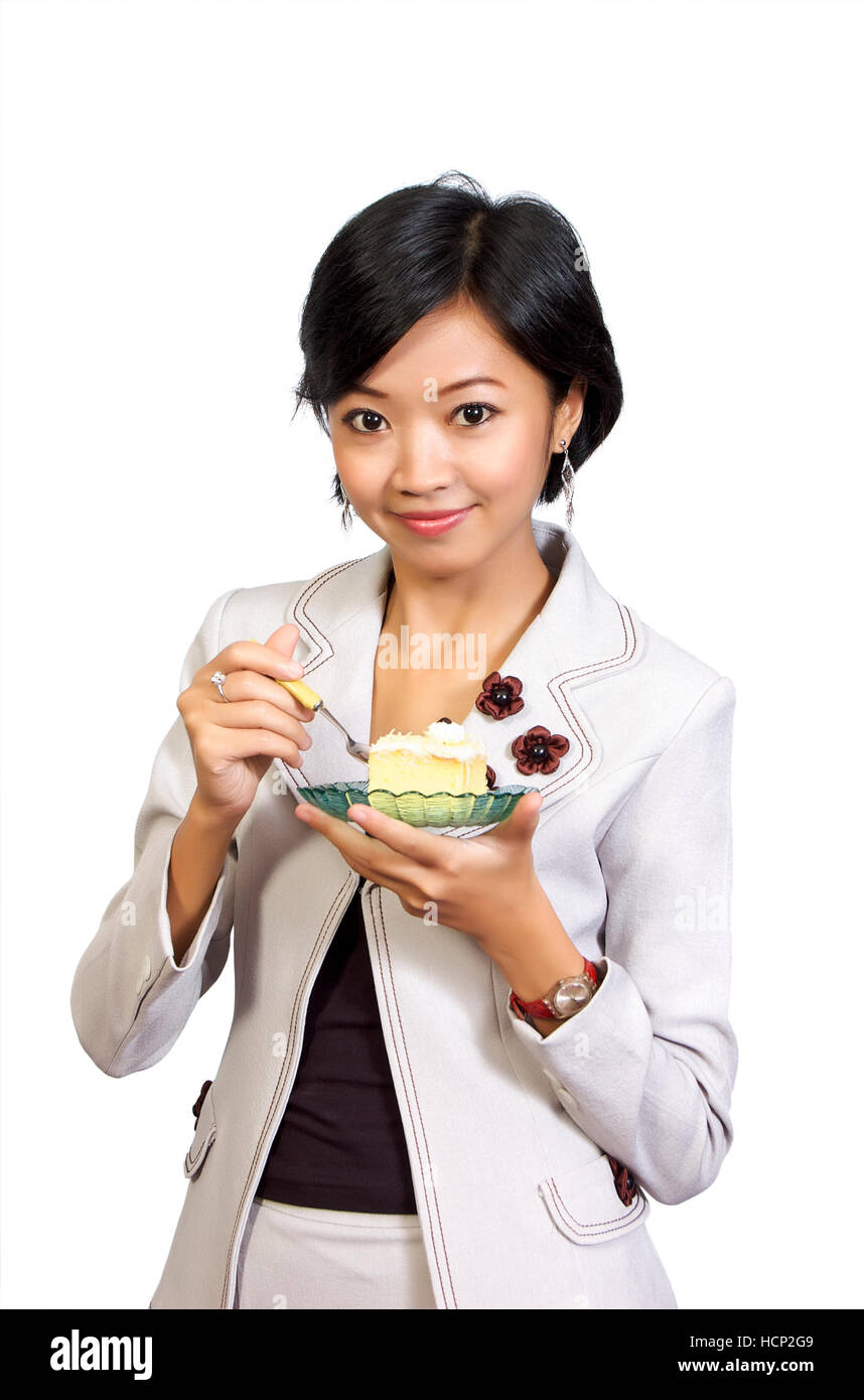 Woman eating cake with fork on the studio. The cake looks delicious ...
