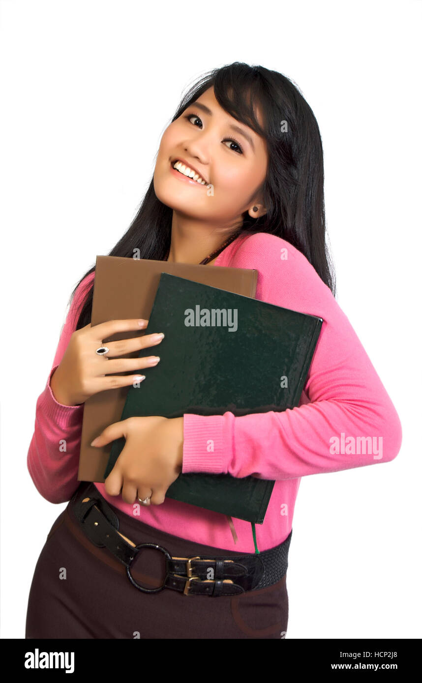 Beautiful college student holding book in her hand. She looks happy and ...