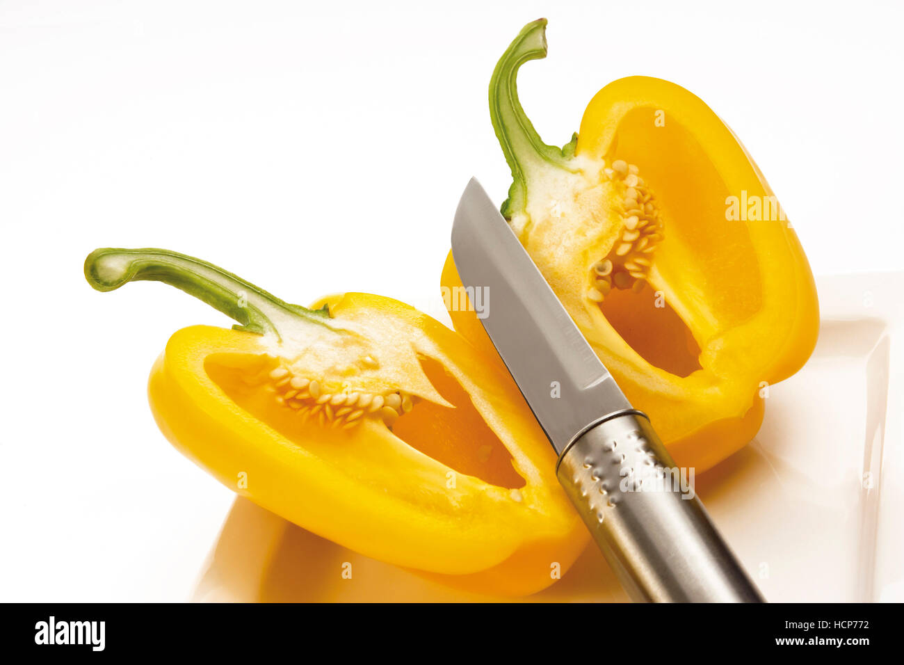 Yellow capsicum cut in half with a knife Stock Photo - Alamy
