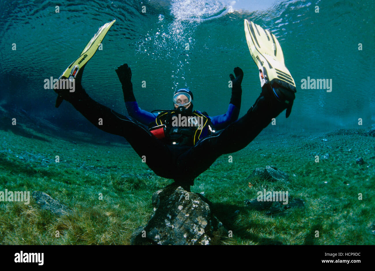 Diver in the Gruener See Lake, trying to sit down on a rock, Tragoess ...