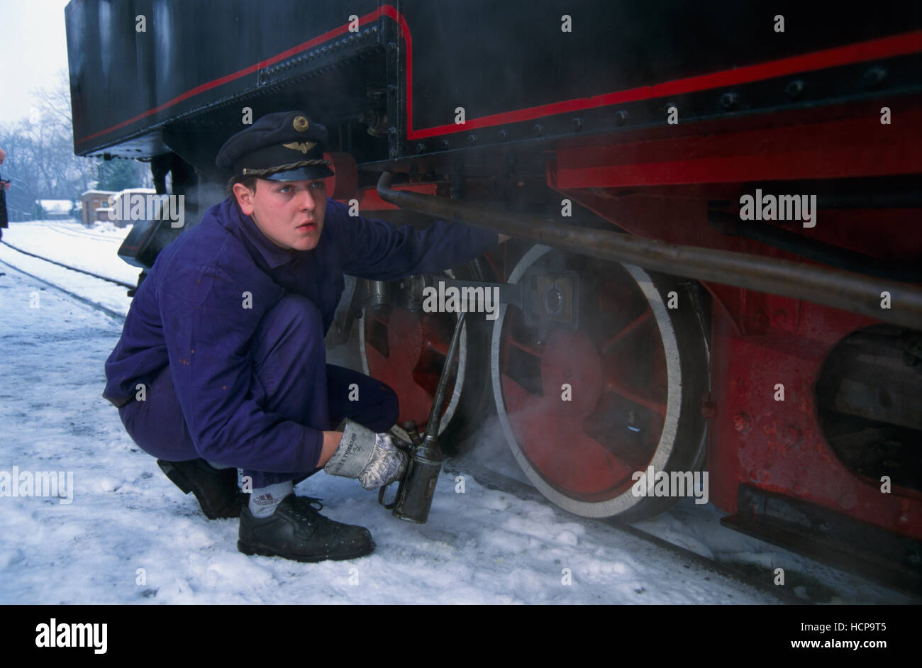 Steam train driver oiling his Steyrtalbahn railway locomotive in Upper ...