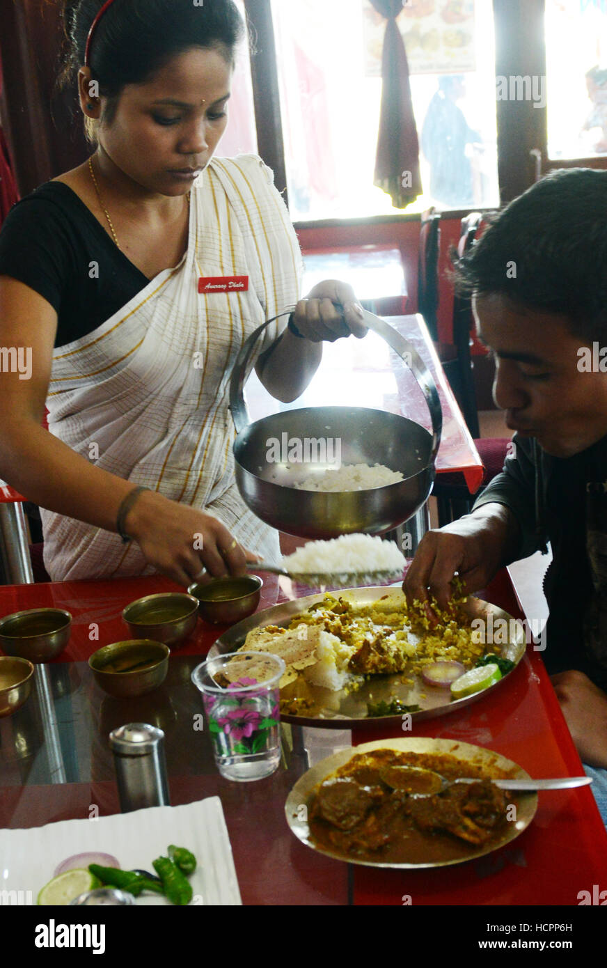 A waitress adding rice to a Thali plate Stock Photo - Alamy