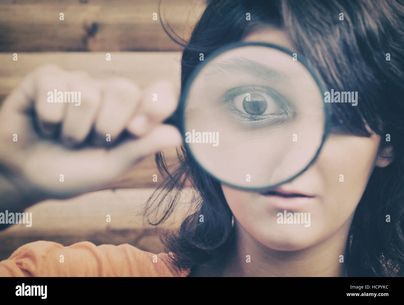 Girl looking through a magnifying glass Stock Photo - Alamy