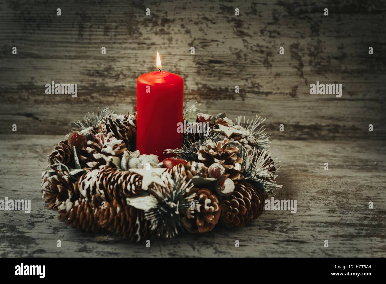Burning candle in a Christmas wreath with seasonal decorations Stock ...