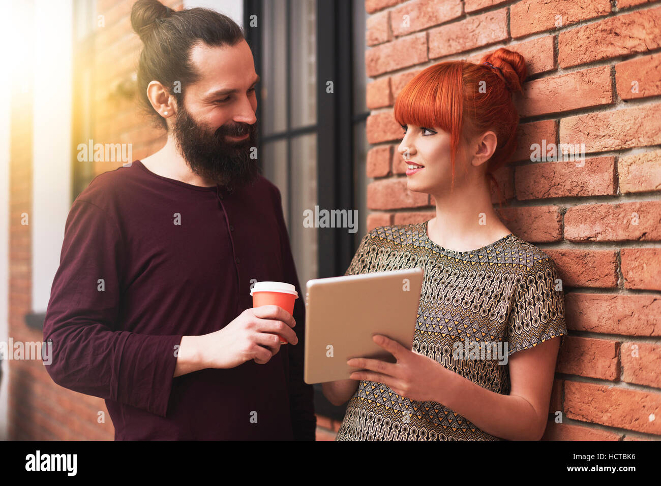 Two young people talking each other at the office Stock Photo - Alamy