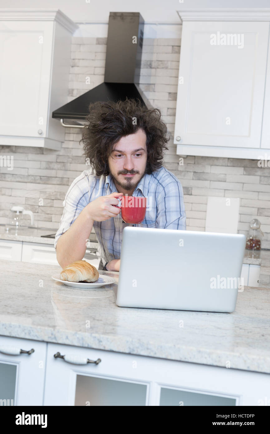 Man Eating Breakfast Using Laptop, Man in kitchen drinking coffe Stock ...