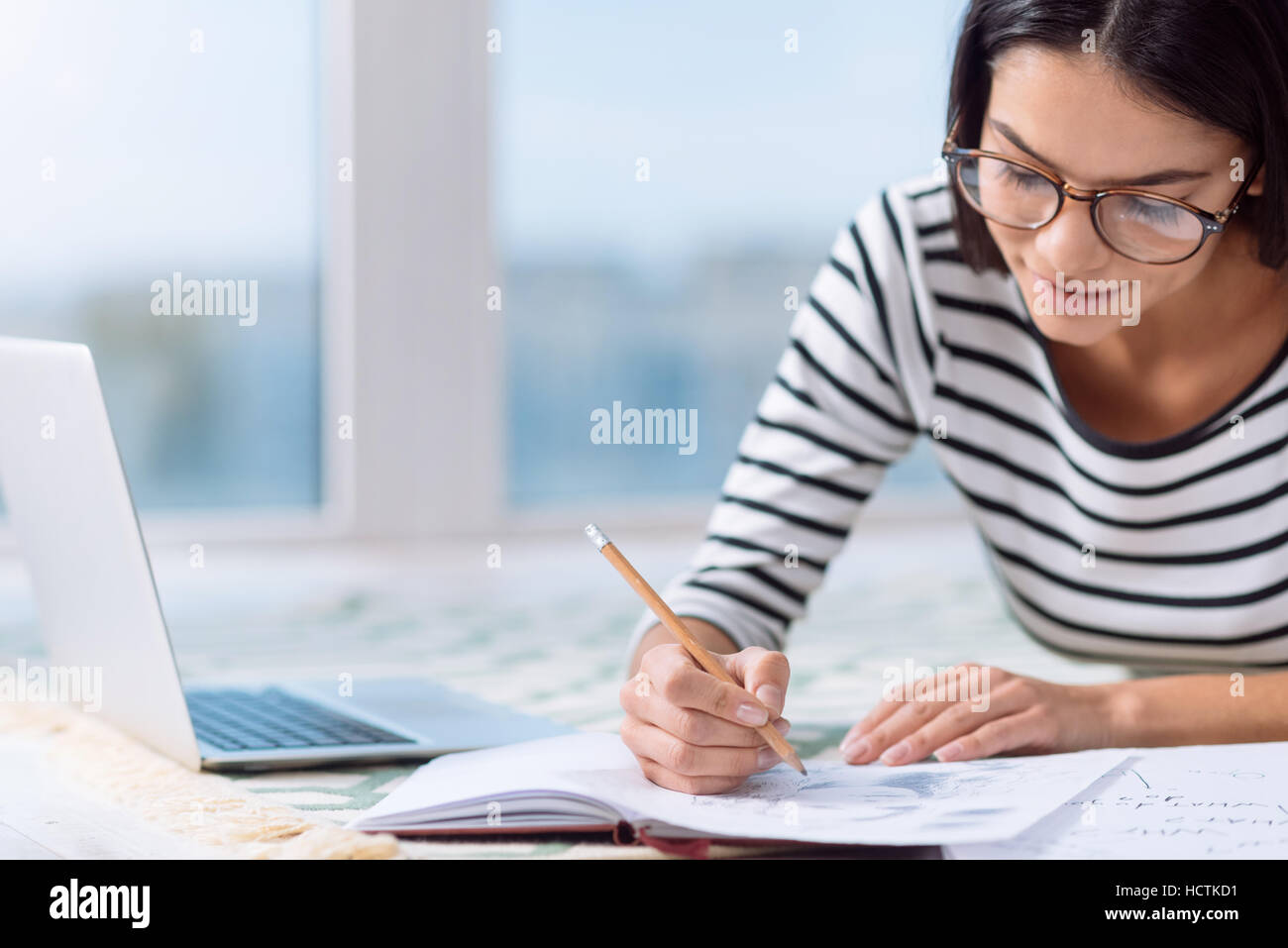 Concentrated woman making notes at home Stock Photo - Alamy