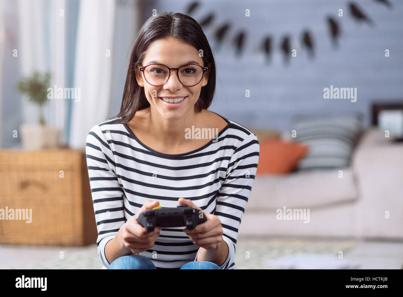 Cheerful young woman playing the game console at home Stock Photo - Alamy