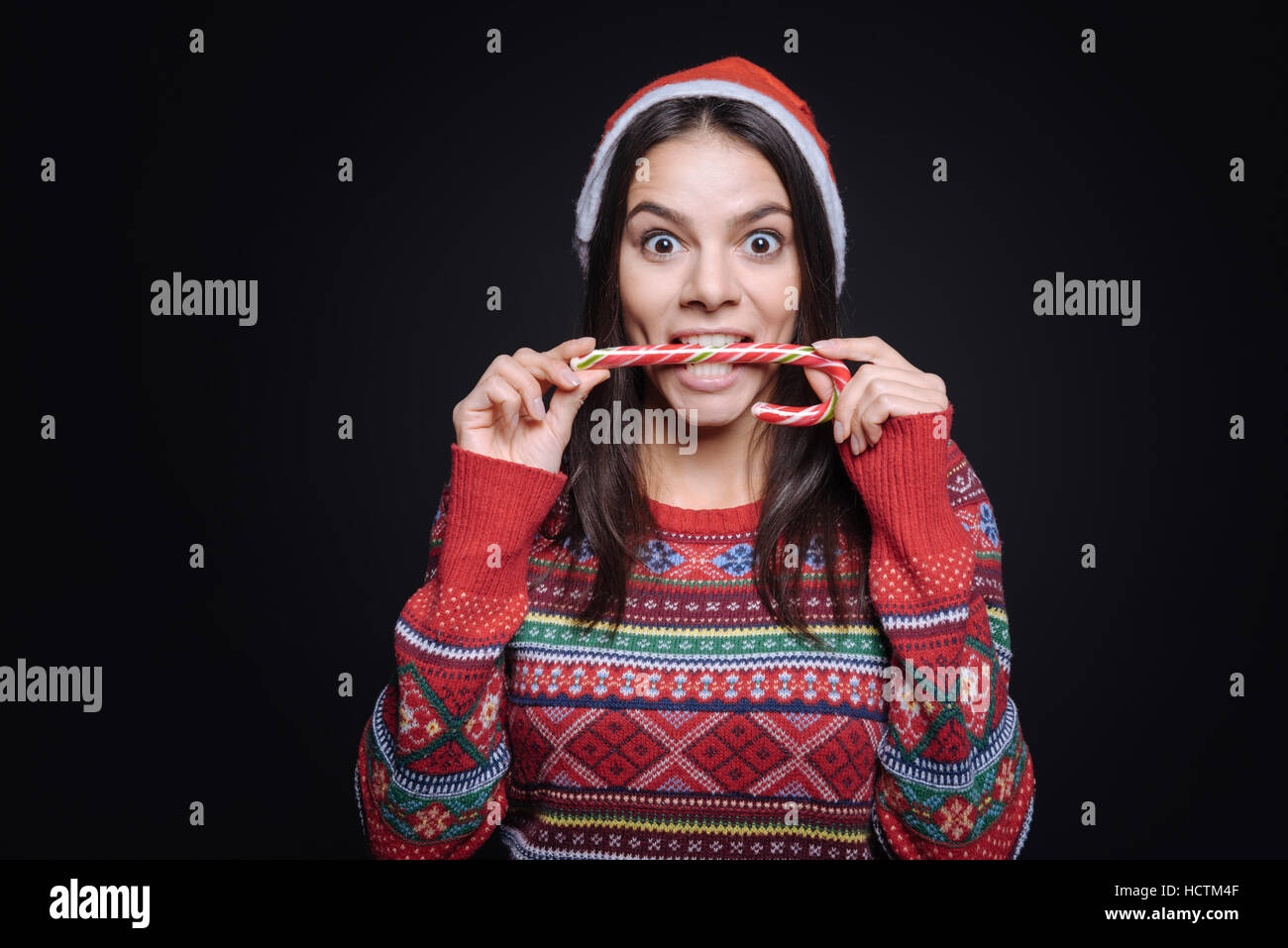 Joyful young girl eating the candy stick in the studio Stock Photo - Alamy