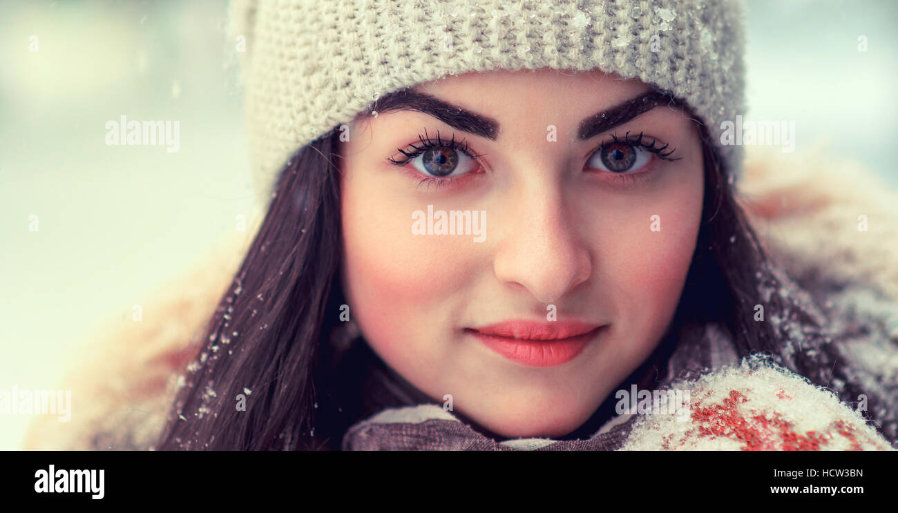 Happy young girl winter portrait in the snow. Close up of the face with ...