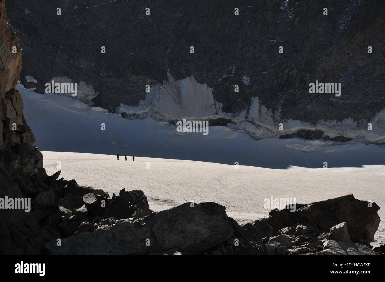 Three men walking through the snow in a glacier Stock Photo - Alamy