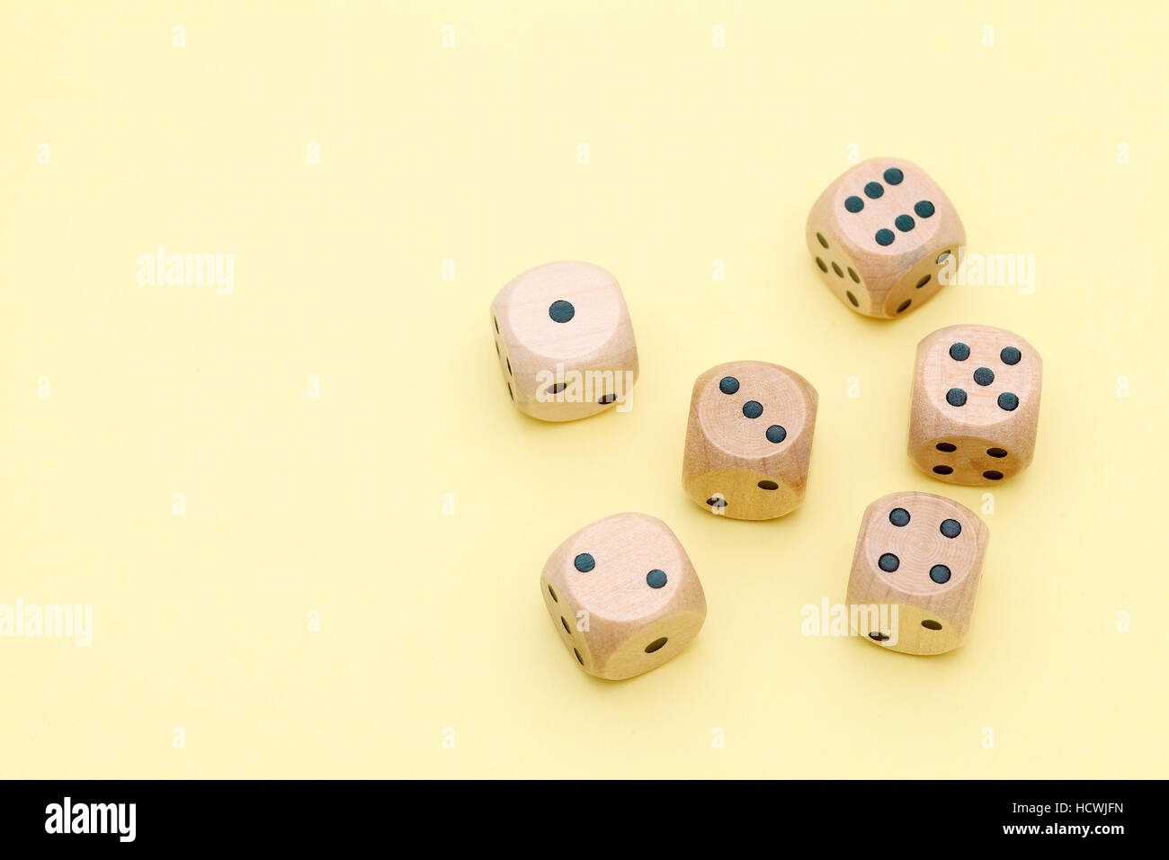 Many wooden dice on a yellow background Stock Photo - Alamy