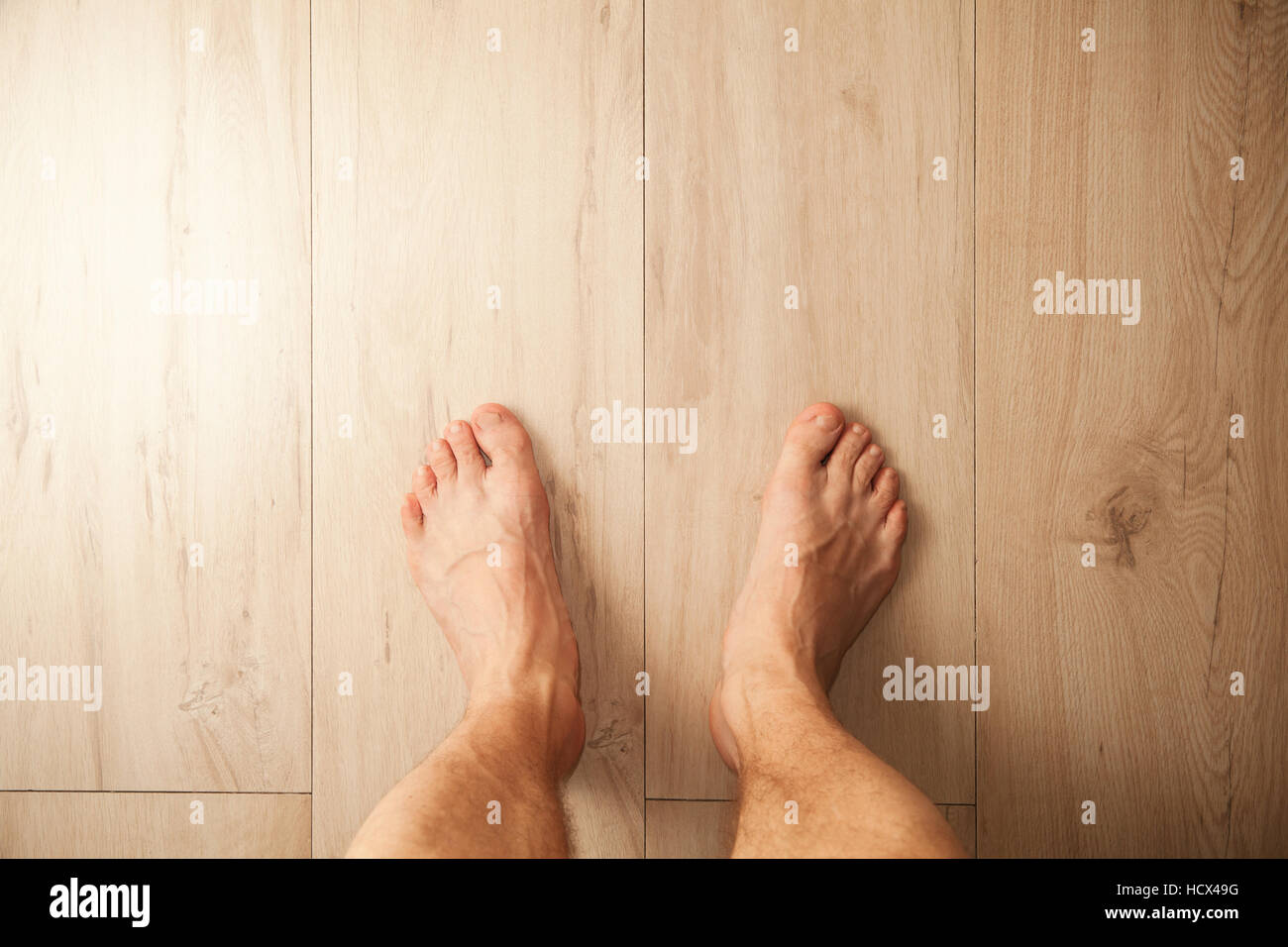 Male feet stand on wooden floor, top view Stock Photo - Alamy