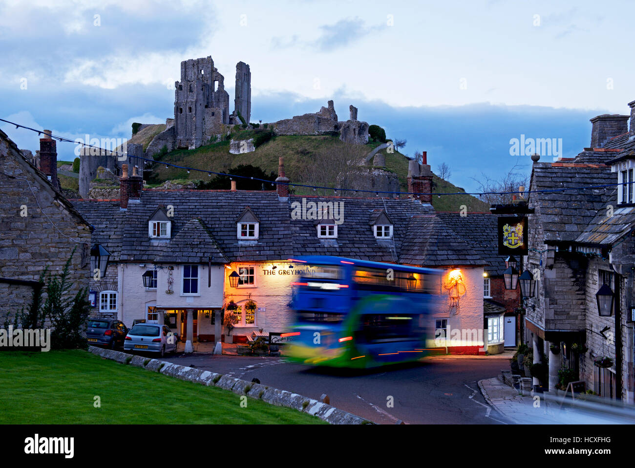 Bus negotiating the narrow road through the village of Corfe Castle ...