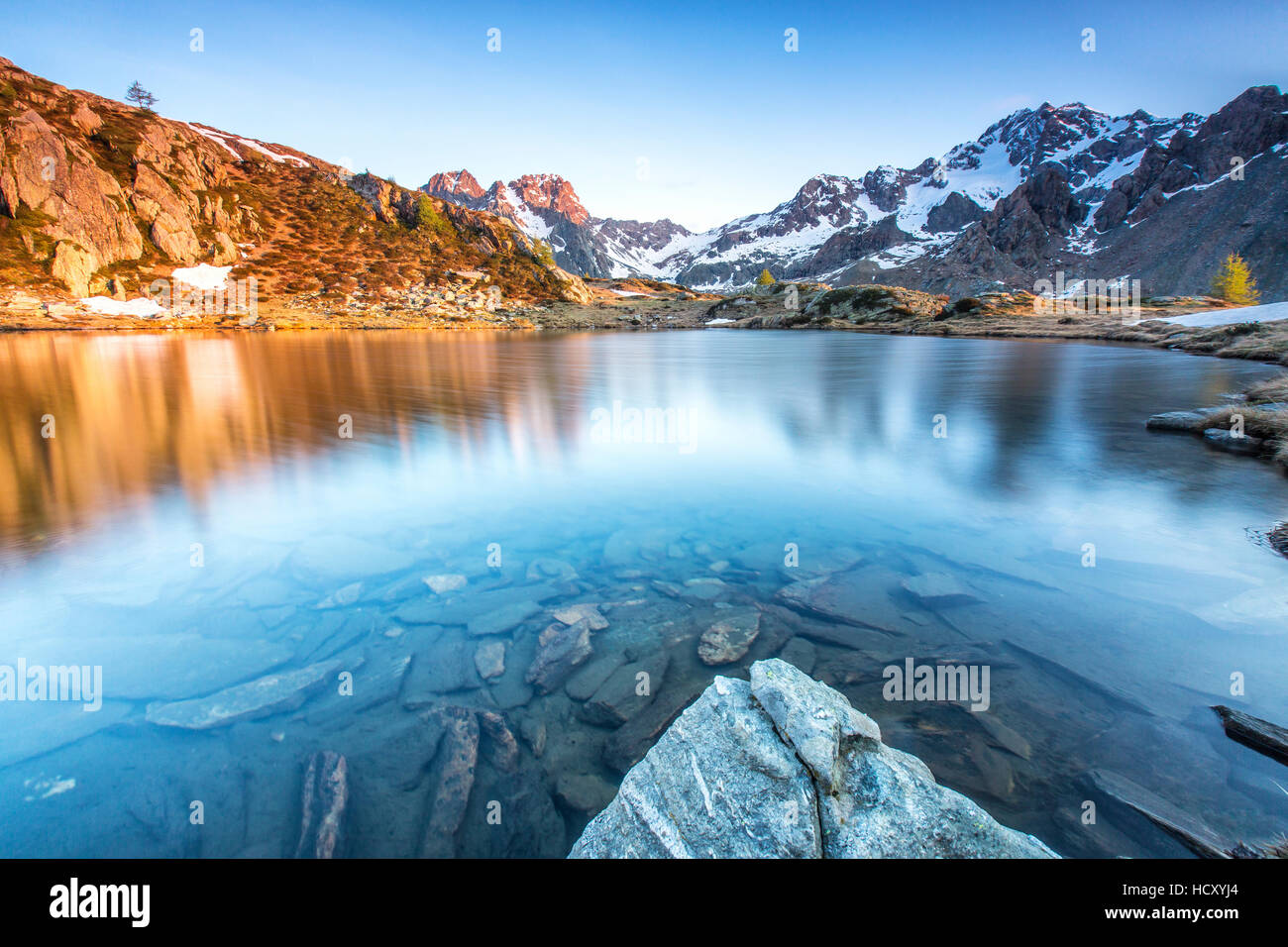 Snowy peaks reflected in Lake Zana at sunrise, Malenco Valley ...