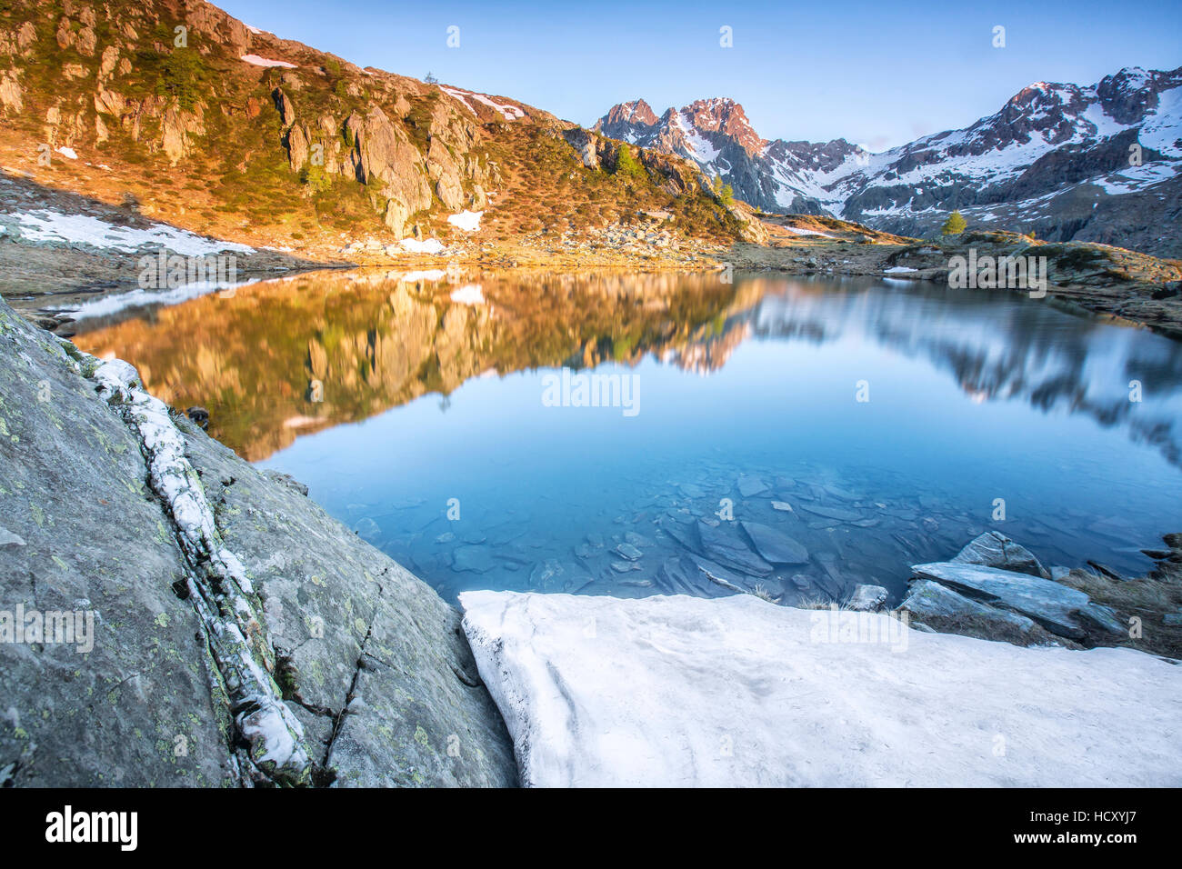 Snowy peaks reflected in Lake Zana at sunrise, Malenco Valley ...