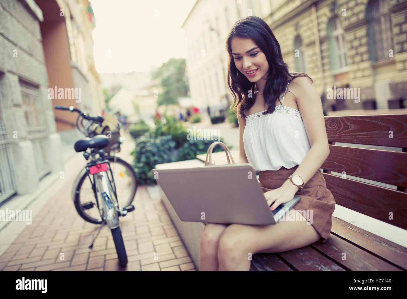 Female student using laptop in city Stock Photo - Alamy