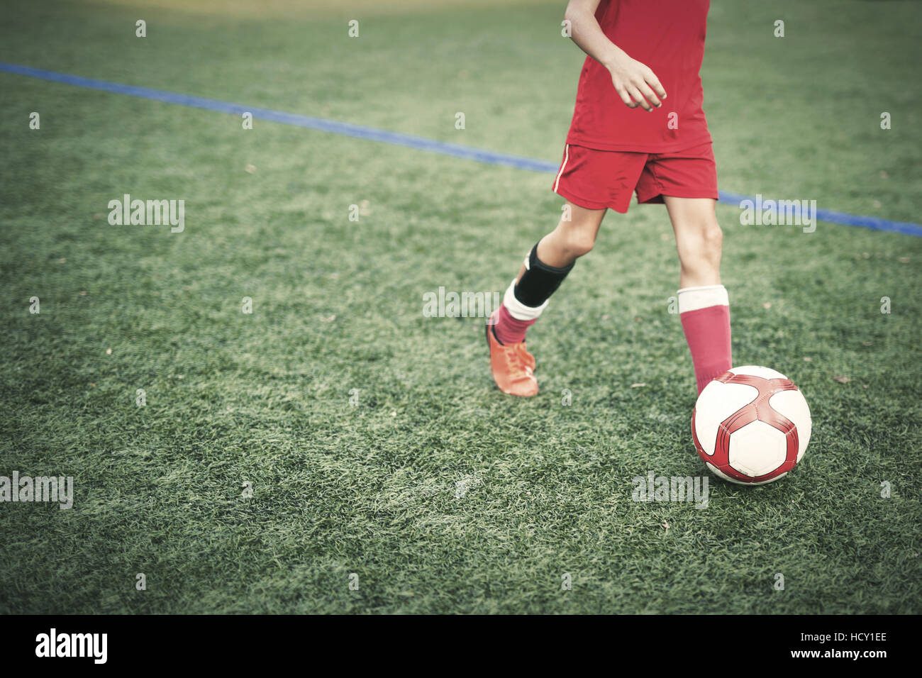 Kid practicing soccer on football field Stock Photo - Alamy