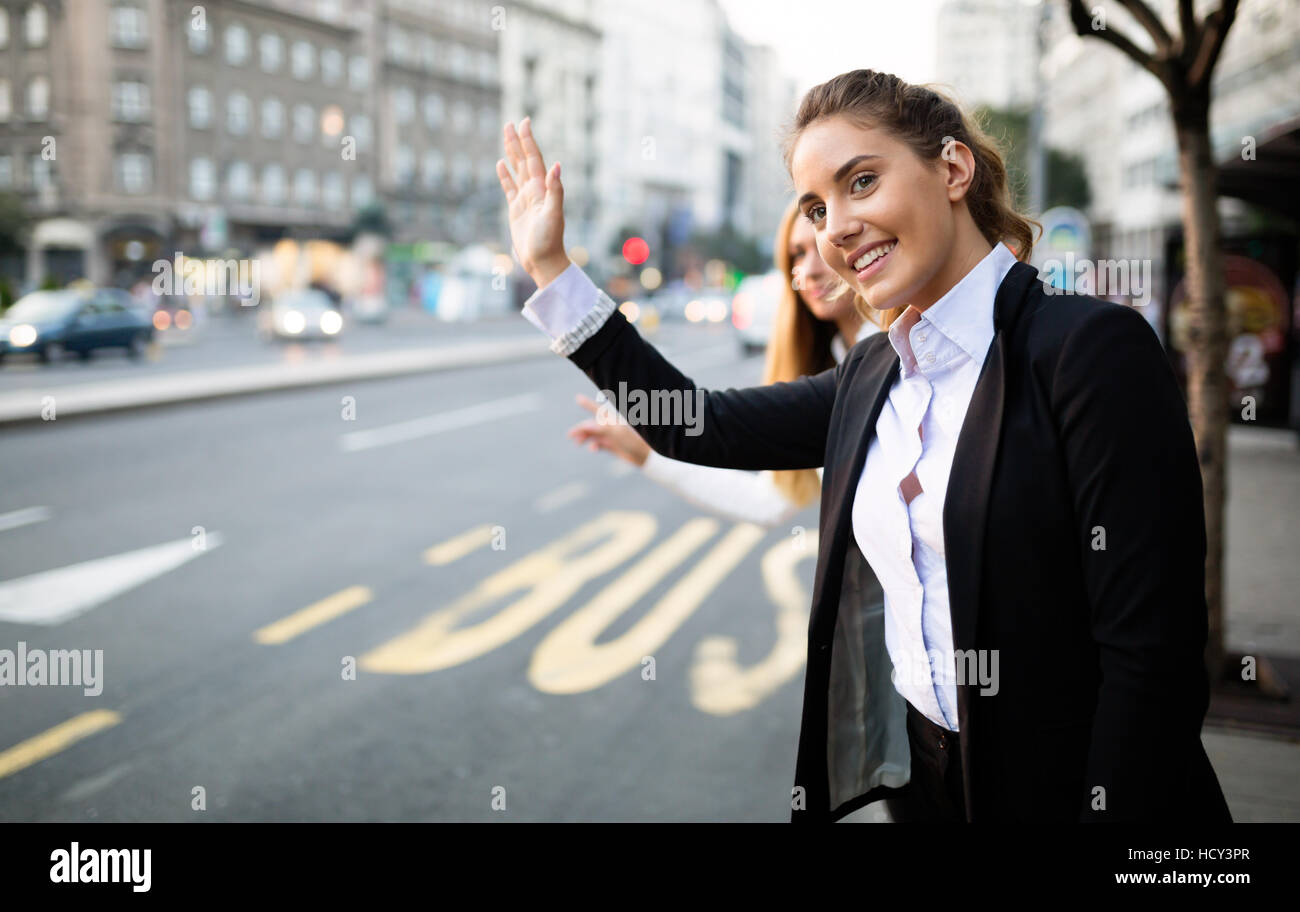 Business women hailing taxi on street Stock Photo - Alamy