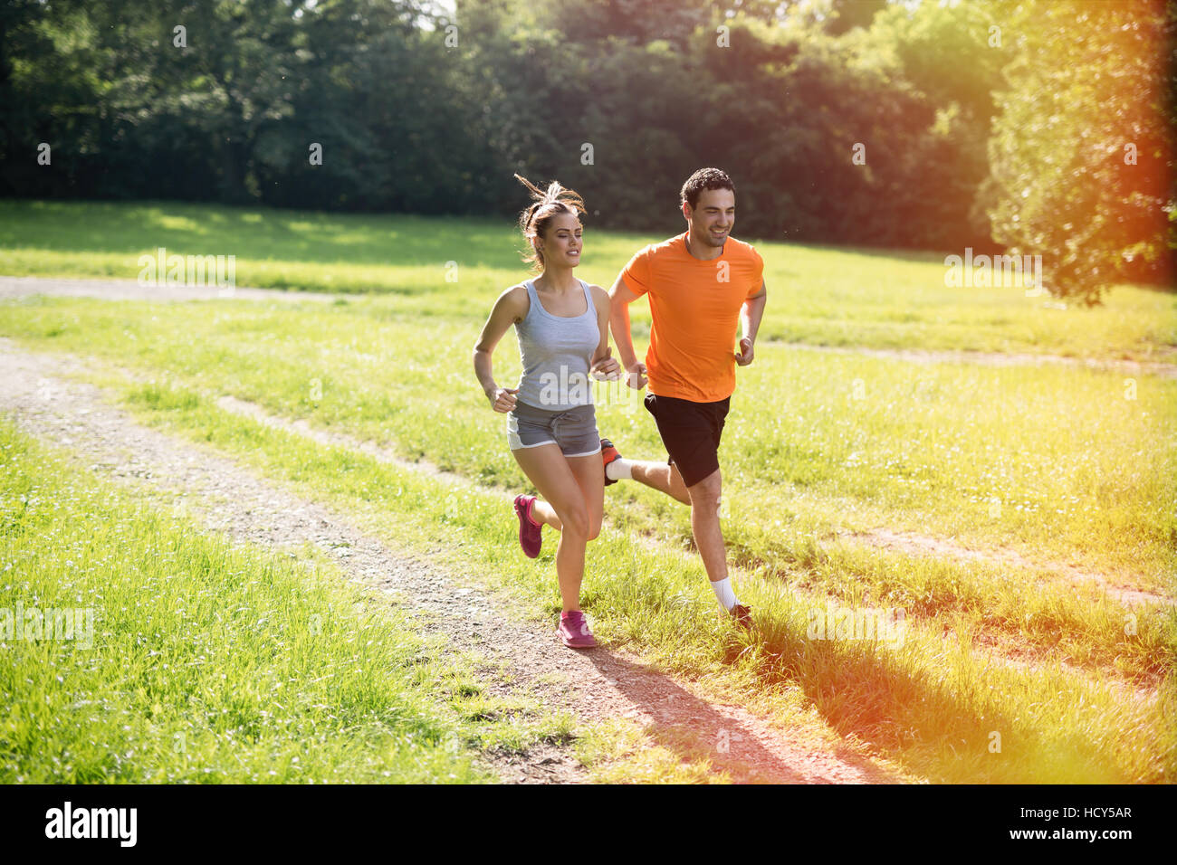 Healthy fit, sportive couple running in nature Stock Photo - Alamy
