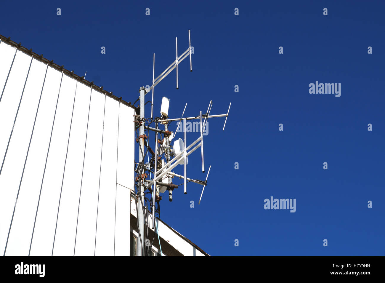 Telecommunication towers with TV antennas and satellite dish on clear ...