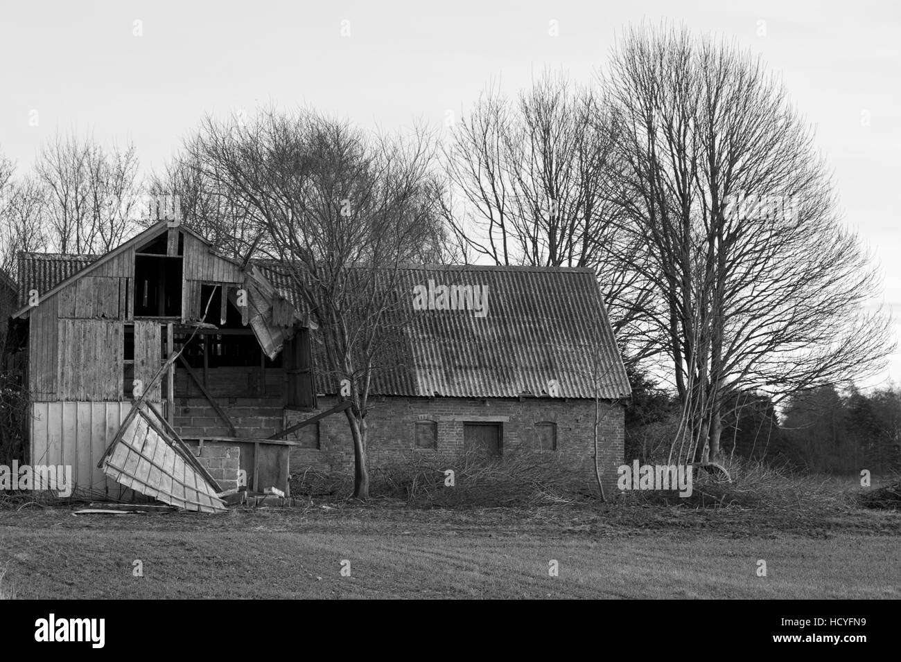 Black and white shot of an old farmhouse barn damaged into a storm ...