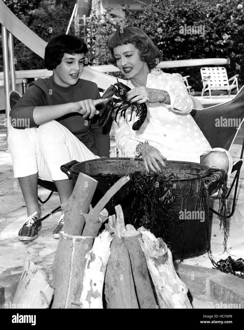 MARGOT MERRILL helps mother BETTE DAVIS prepare a lobster meal in their ...