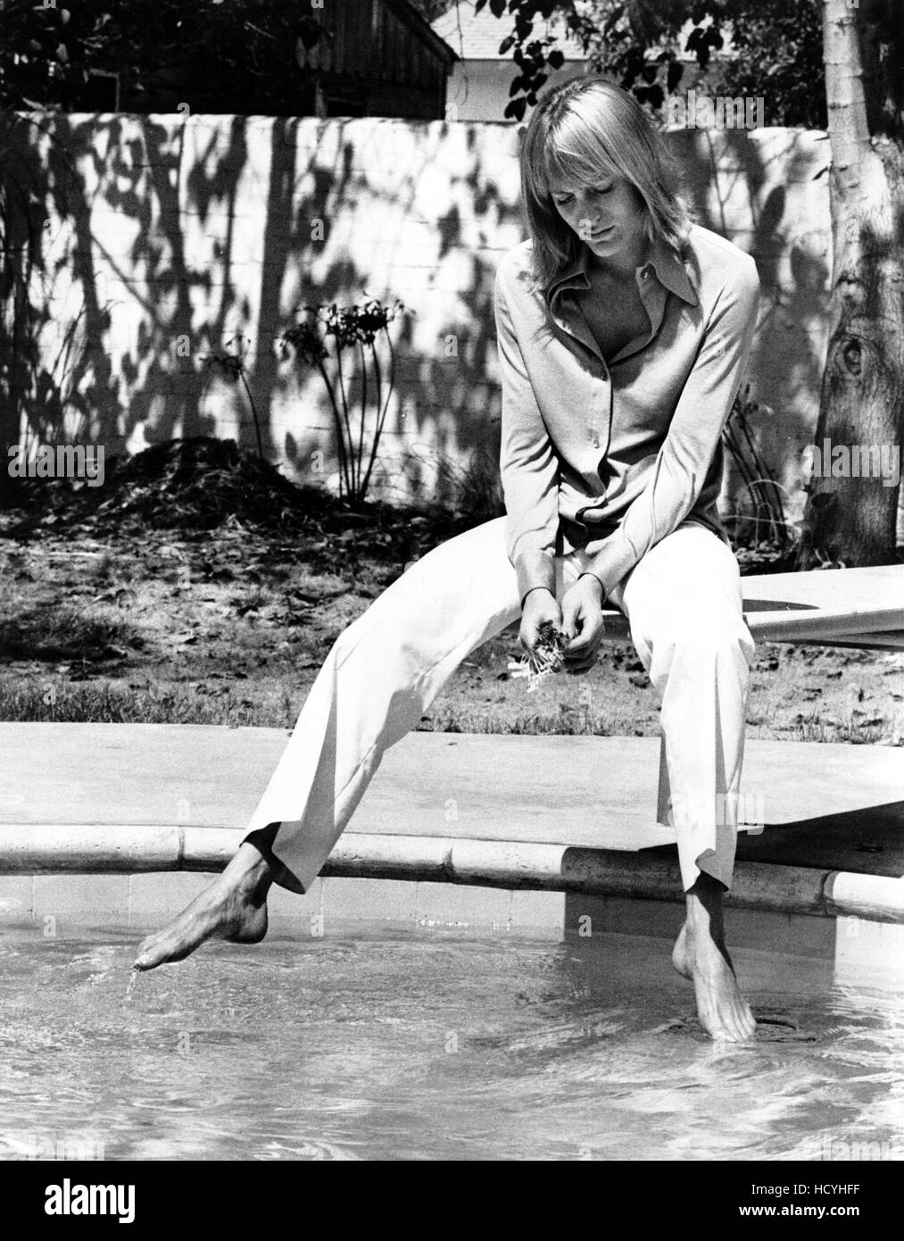 Carrie Snodgress, sits on the springboard of the pool behind her house ...