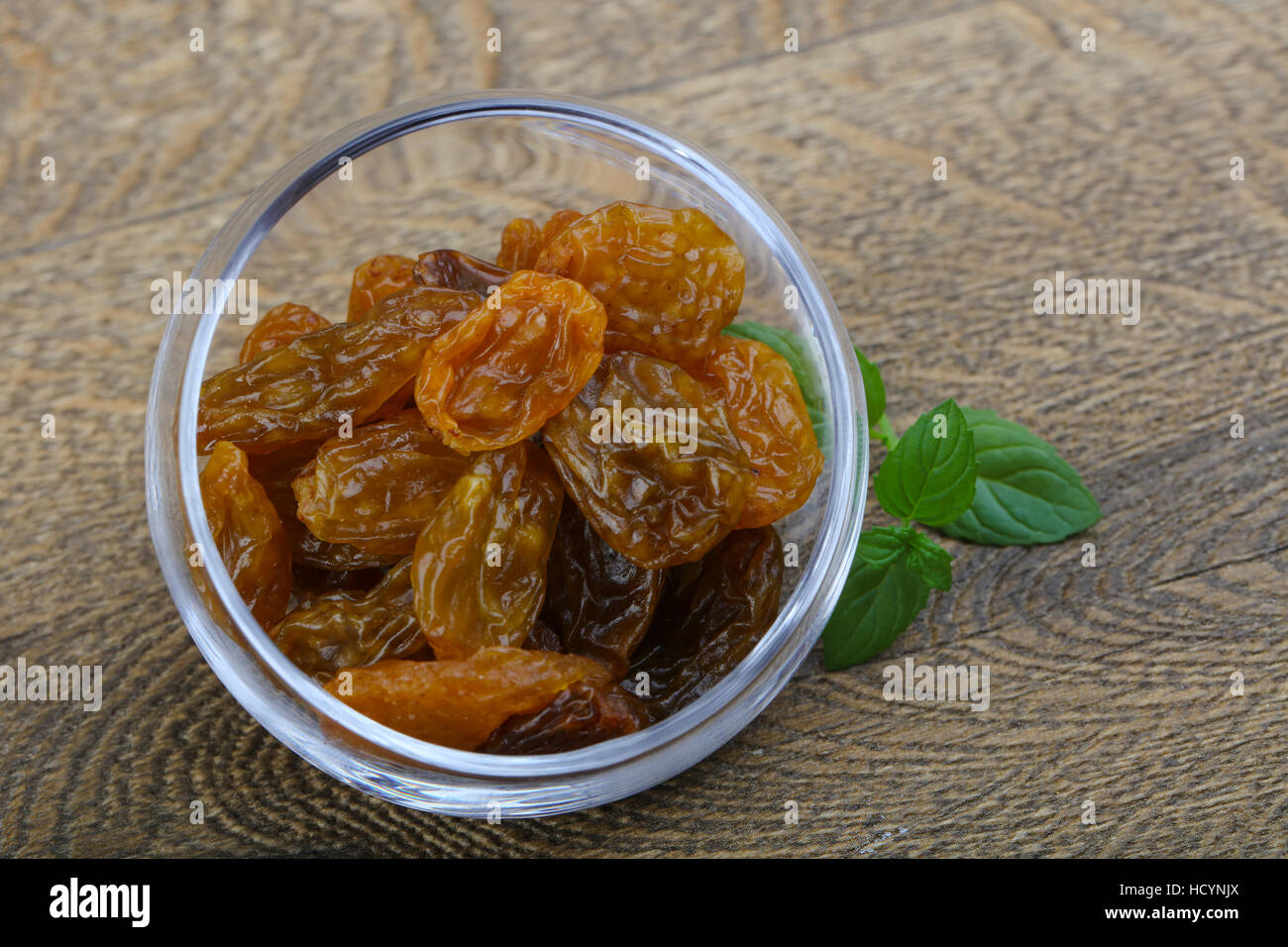 Sweet raisins in the bowl with mint leaves Stock Photo - Alamy
