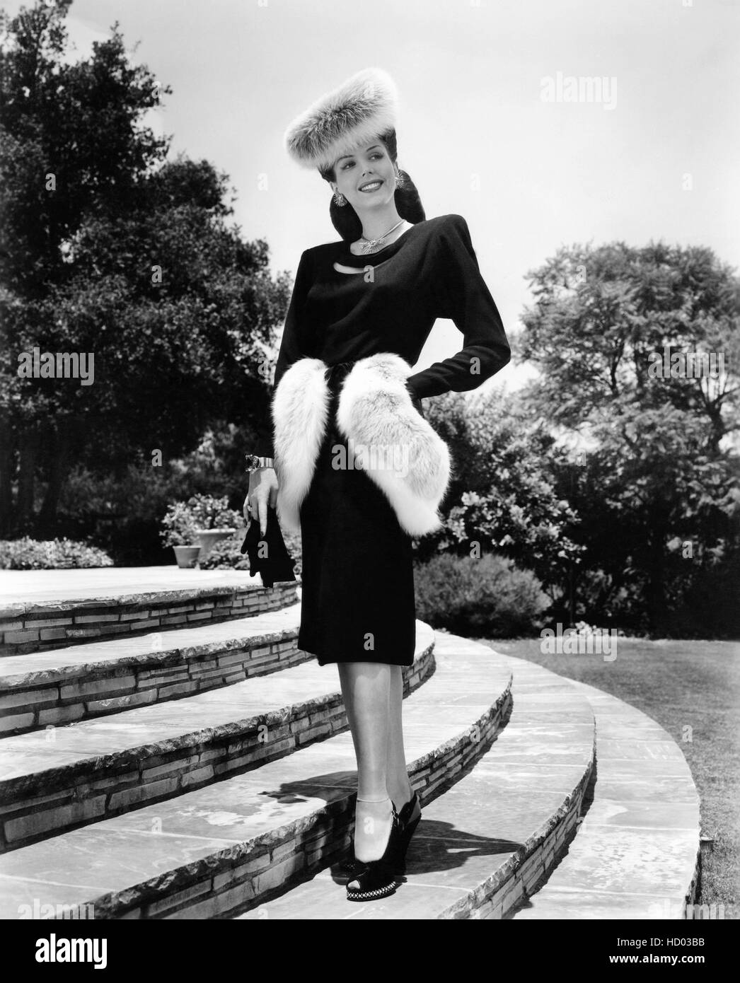 Ann Miller wearing a black dress with detachable fox fur pockets with ...