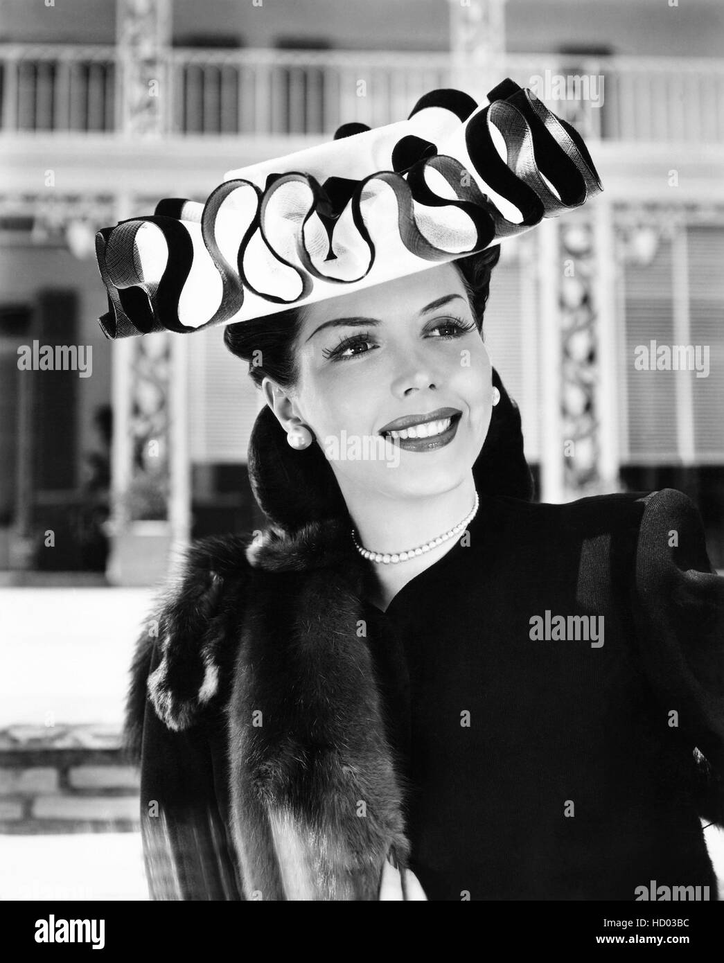 Ann Miller wearing a white felt hat trimmed in black velvet ribbon ...