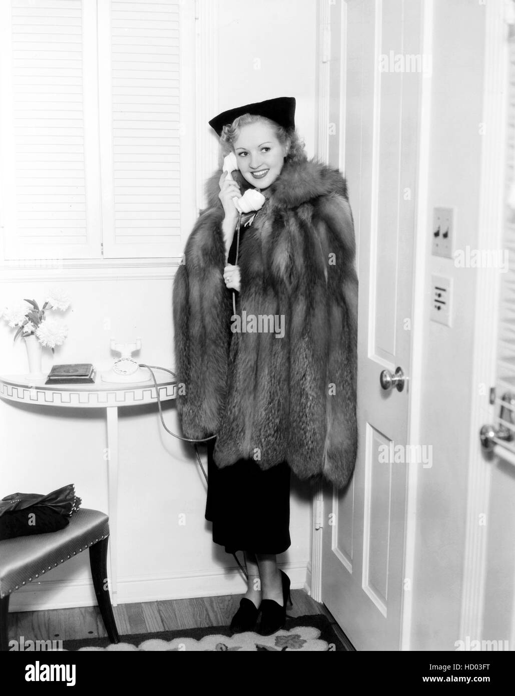 Betty Grable, at home, in a red fox cape and black crepe afternoon ...
