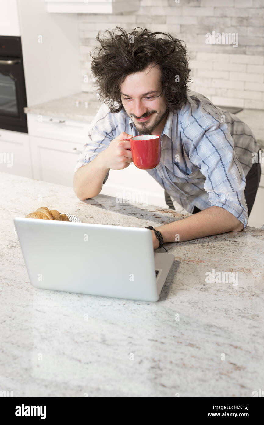 Man Eating Breakfast Using Laptop, Man in kitchen drinking coffe Stock ...