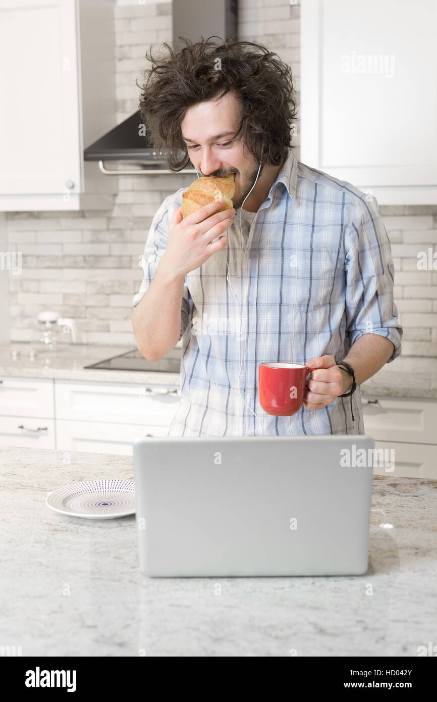 Man Eating Breakfast Using Laptop, Man in kitchen drinking coffe Stock ...