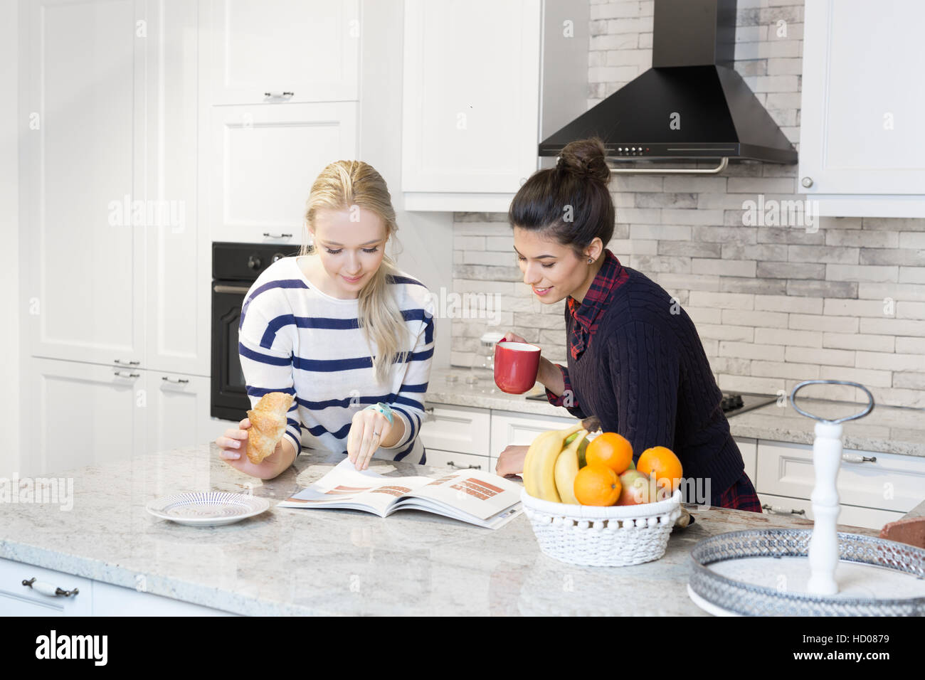Two girls friends preparing breakfast and in a kitchen concept cooking ...
