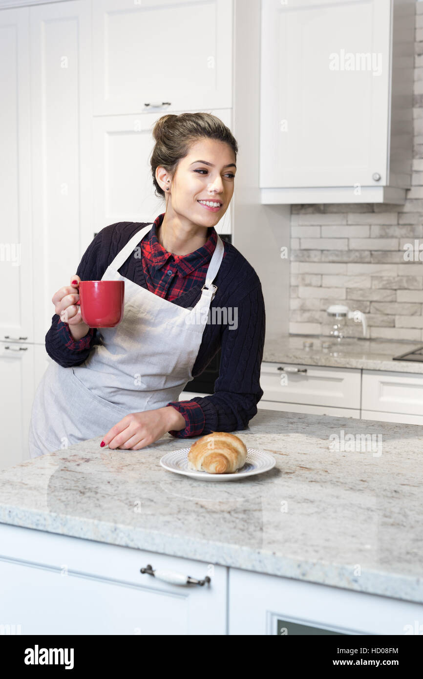 Portrait of a smiling woman cooking in her kitchen Stock Photo - Alamy