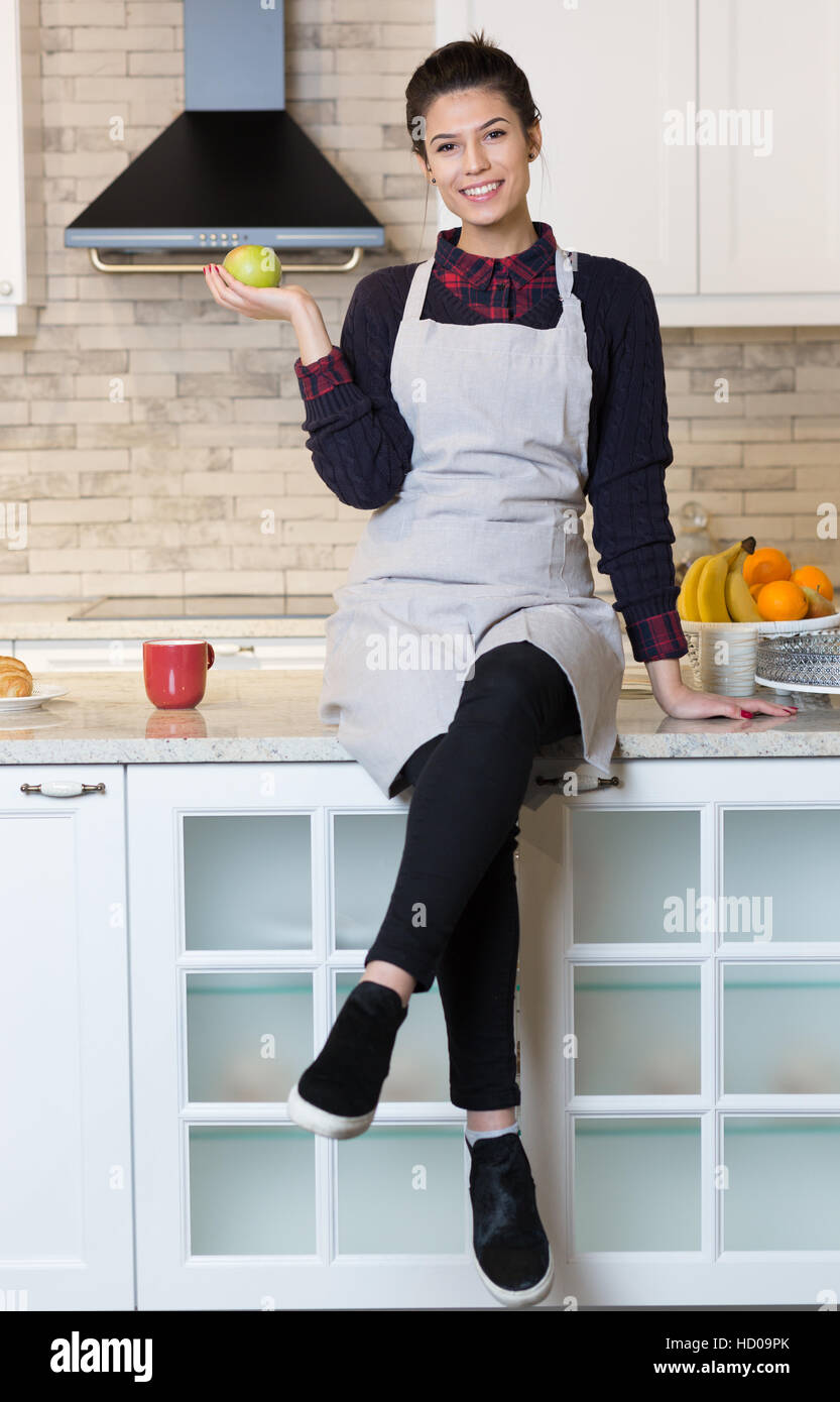 Portrait of a smiling woman cooking in her kitchen Stock Photo - Alamy