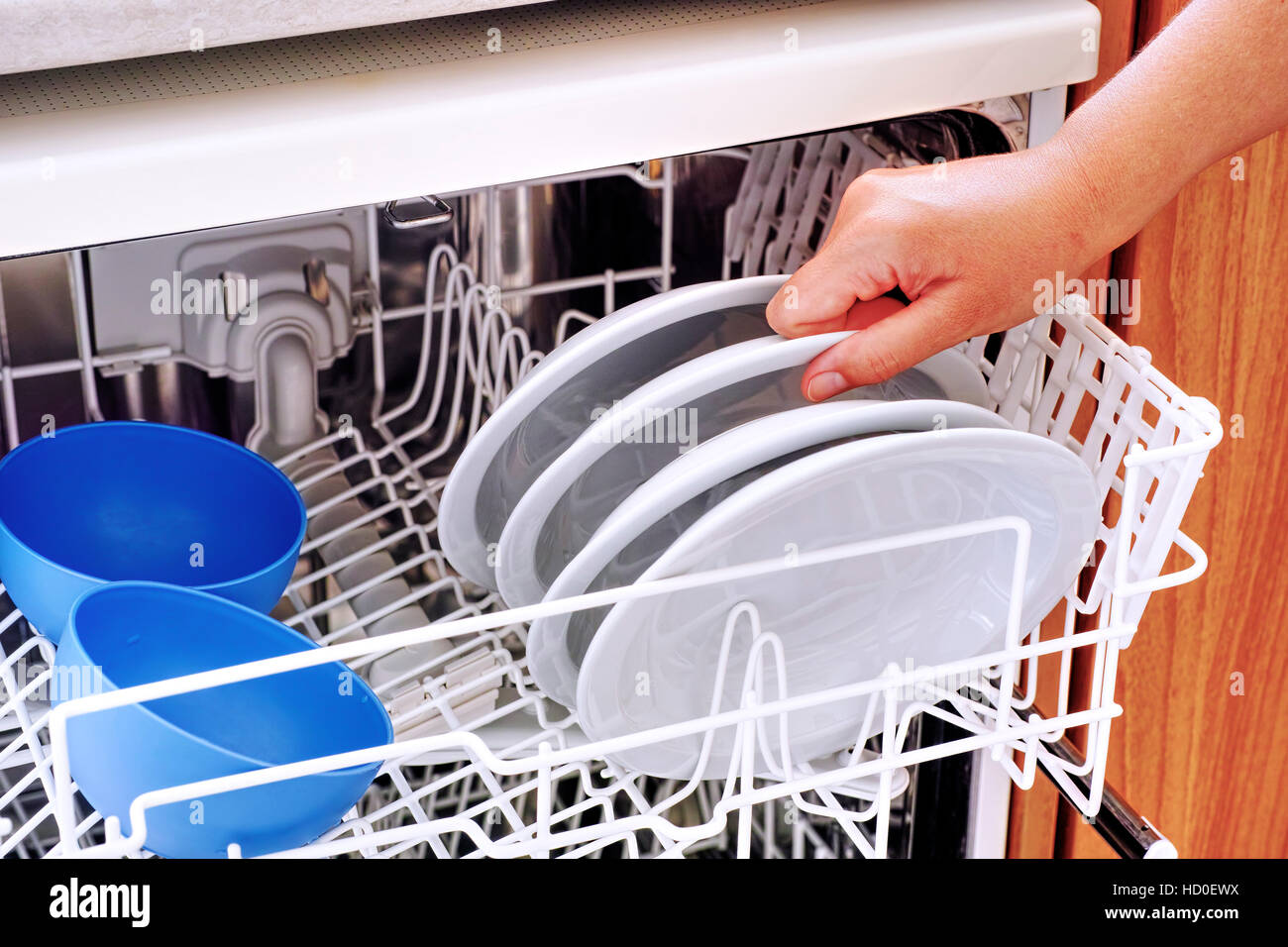Woman hand taking plate from open dishwasher Stock Photo - Alamy