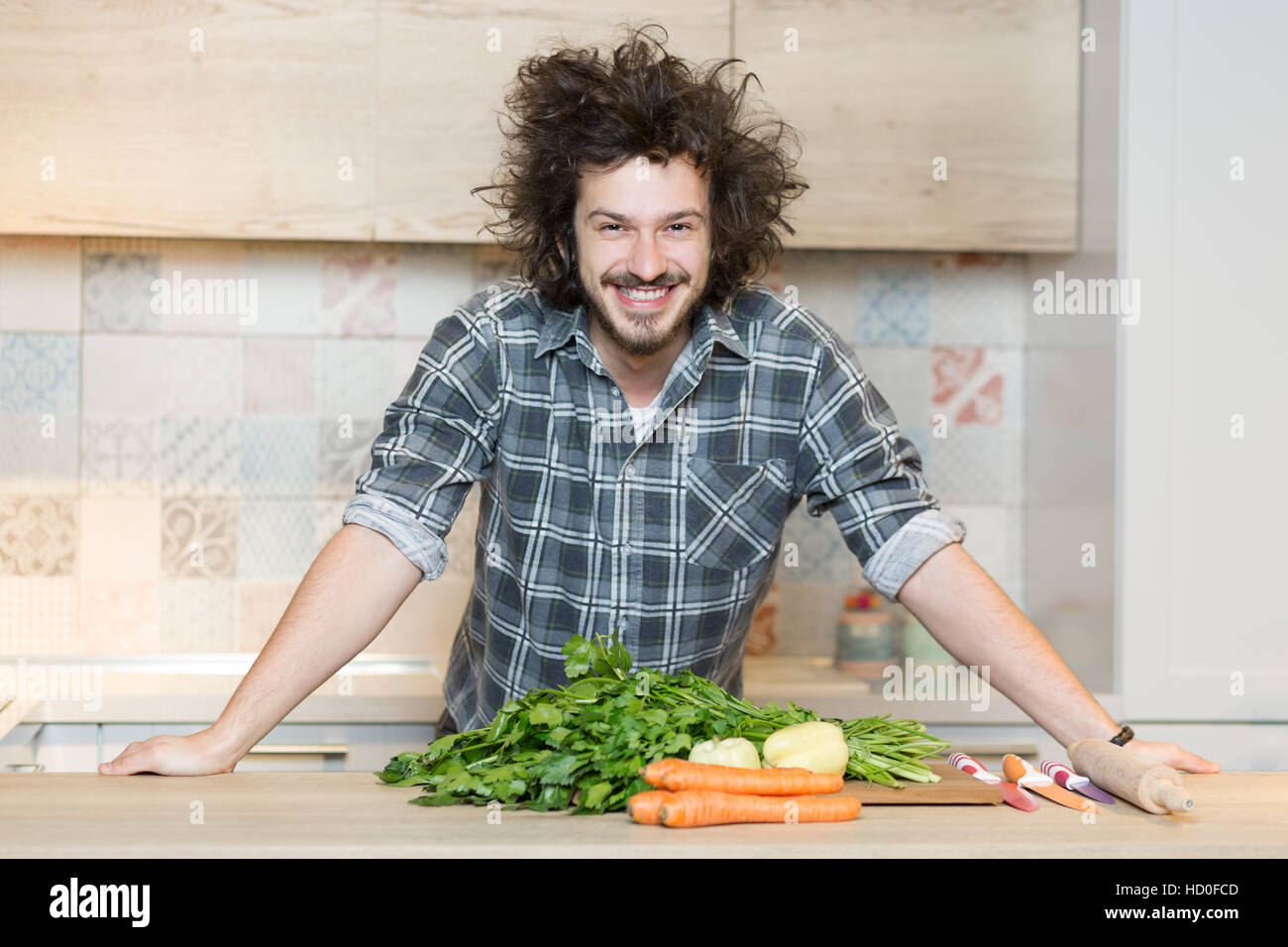 Handsome man cooking vegetable salad in kitchen Stock Photo - Alamy