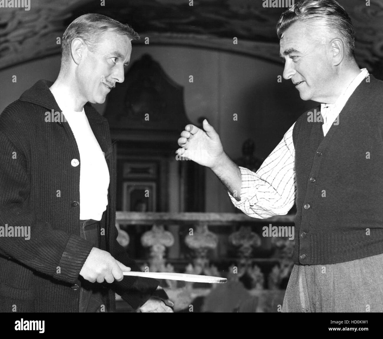 ALEC GUINNESS is shown how to play paddleboard by director CHARLES ...