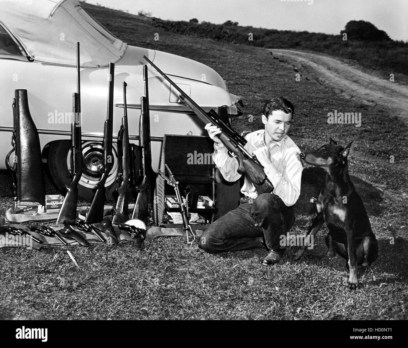 Audie Murphy with Doberman Pinscher, Ranger, displaying his gun ...