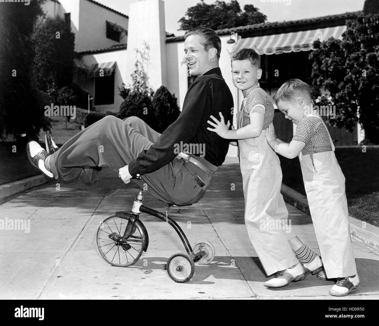 From left: Dan Duryea, Peter Duryea, Richard Duryea riding tricycle, ca ...